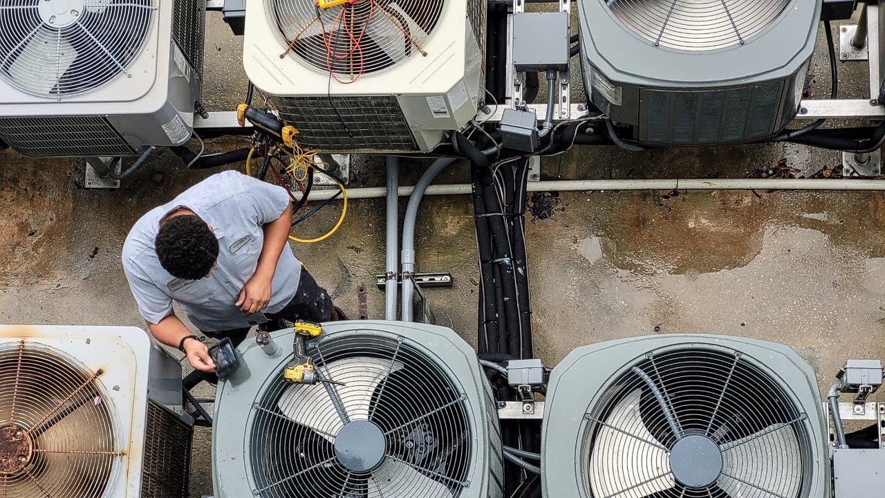 hvac technician inspecting A/C units apartment building | Chicago HVAC ...